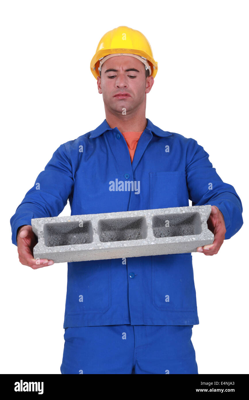 Builder carrying heavy building block Stock Photo - Alamy