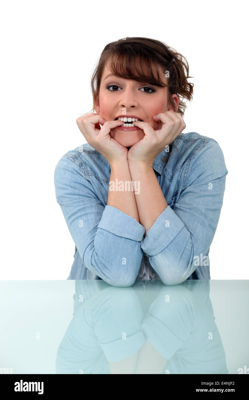 Nevous brunette chewing fingernails Stock Photo - Alamy