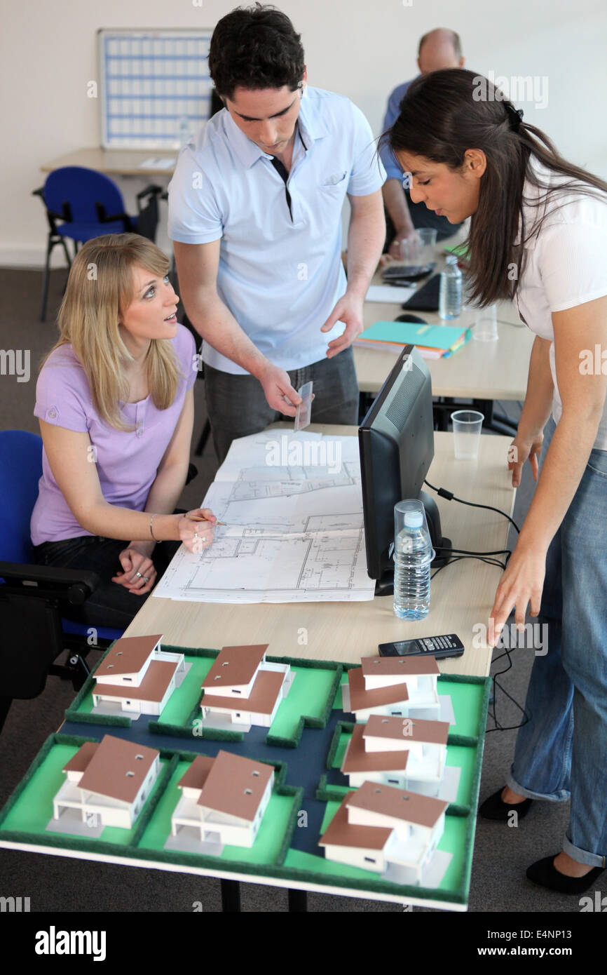 Office workers looking at architect plans Stock Photo - Alamy