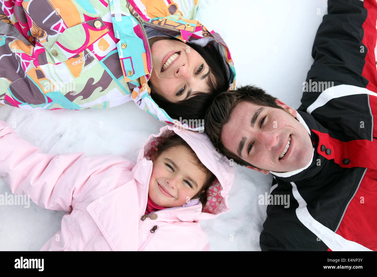 Family laying in the snow Stock Photo - Alamy