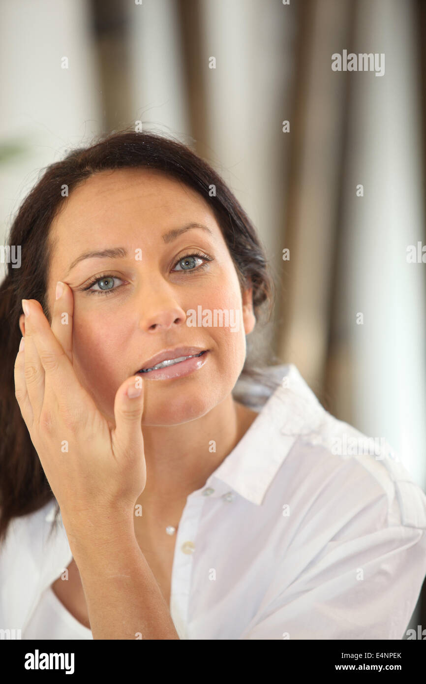 Woman applying eye cream Stock Photo - Alamy
