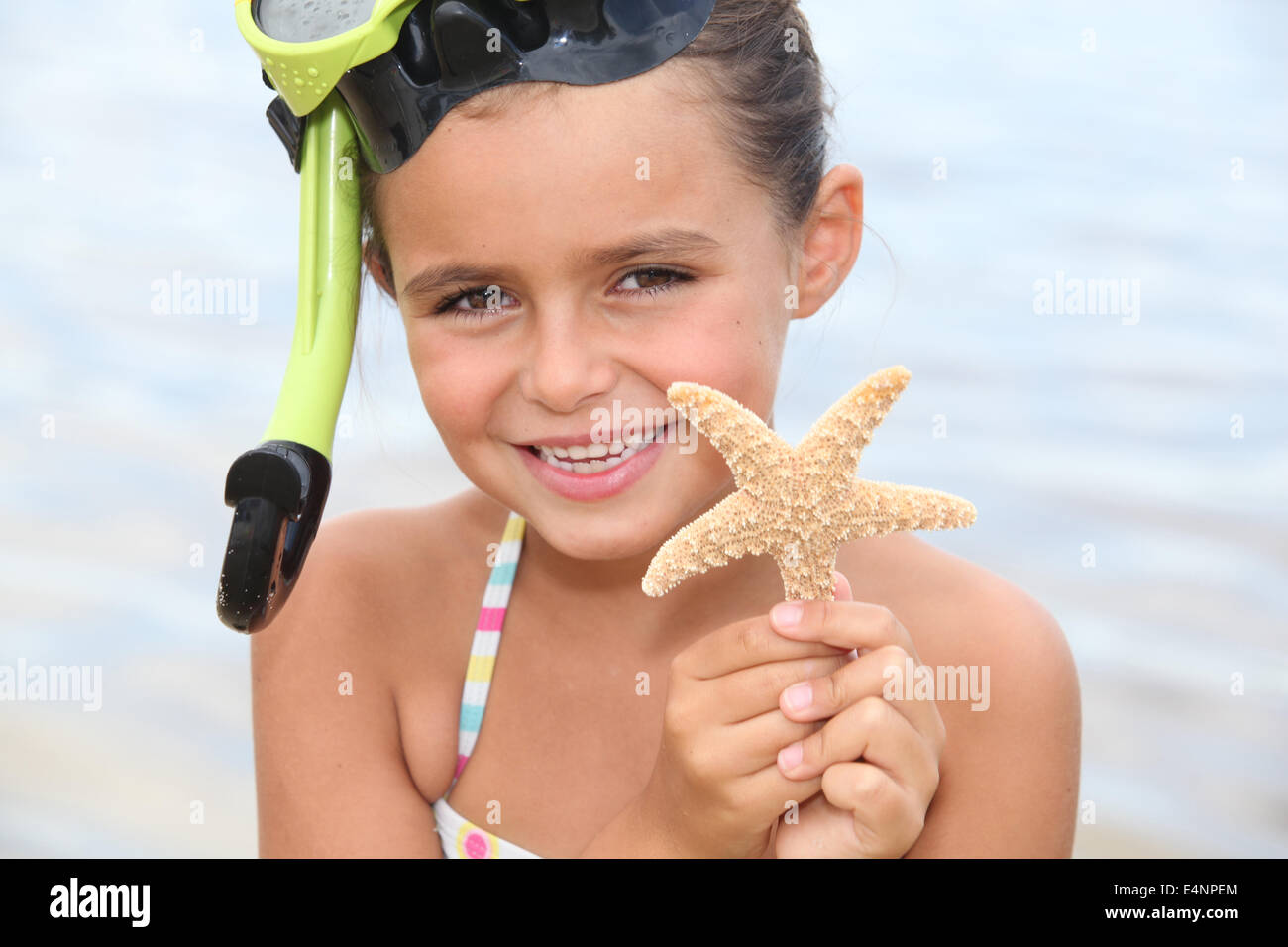 Little girl at the beach holding star fish Stock Photo - Alamy