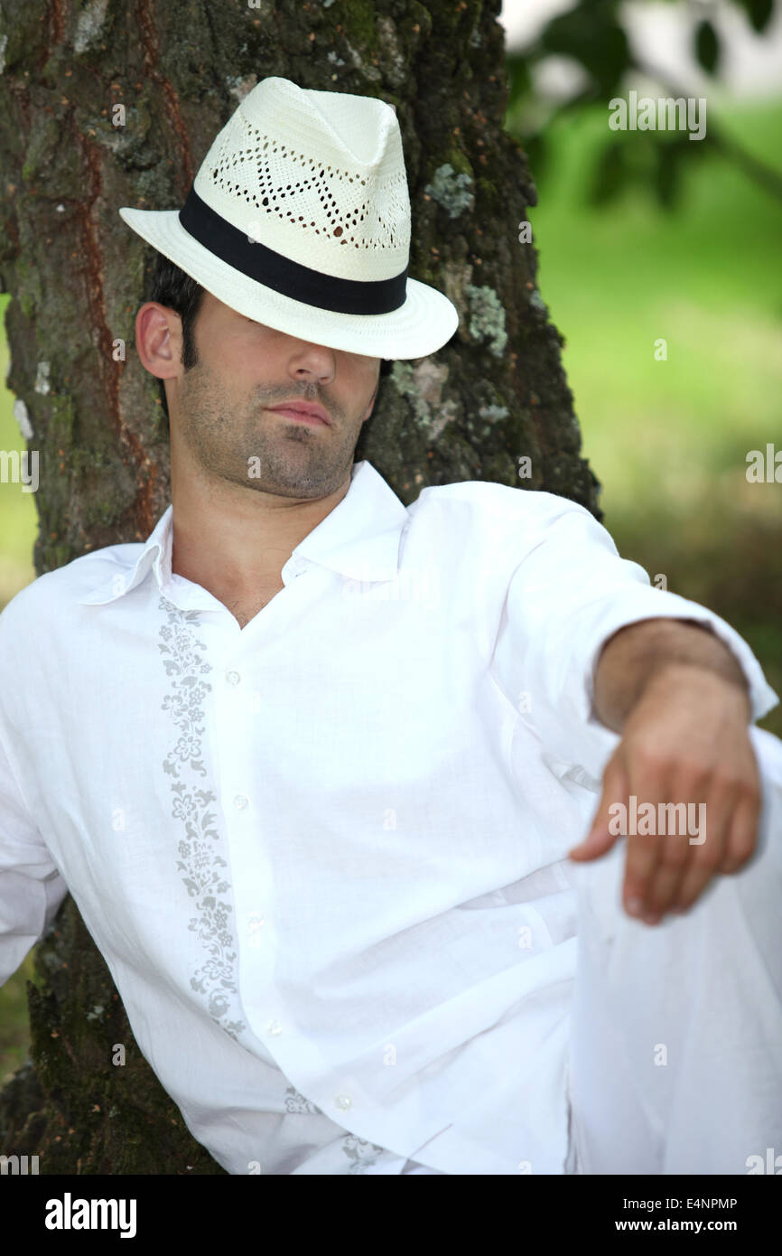 Man sleeping under tree Stock Photo - Alamy