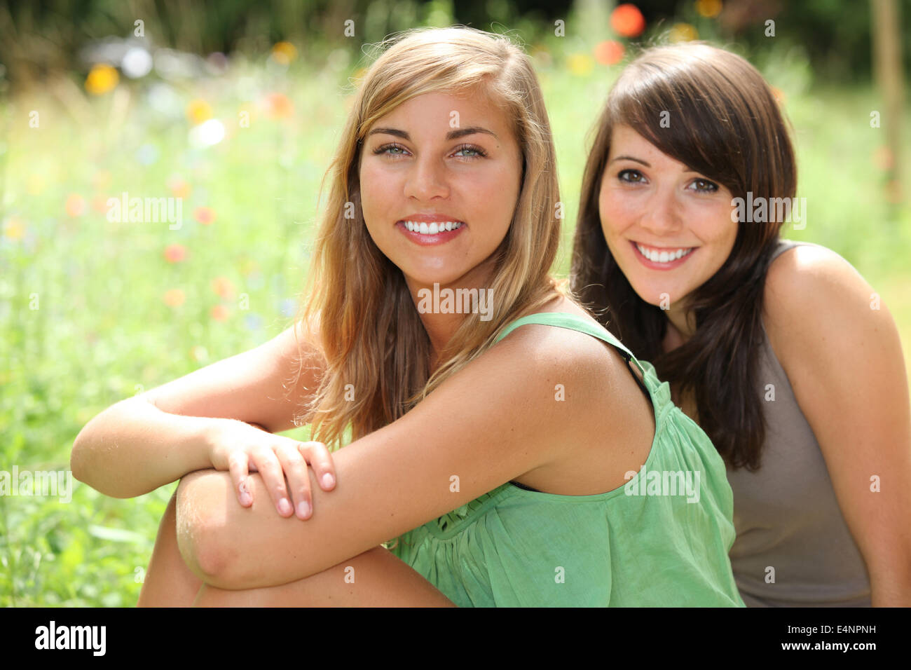 Girls sitting in a field Stock Photo - Alamy