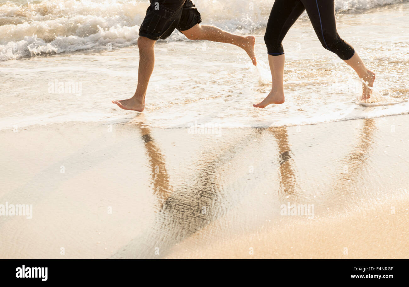 USA, Florida, Palm Beach, Couple running on beach, low section Stock ...