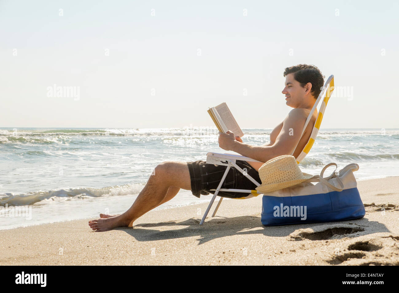 USA, Florida, Palm Beach, Side view of man sitting on deckchair and ...