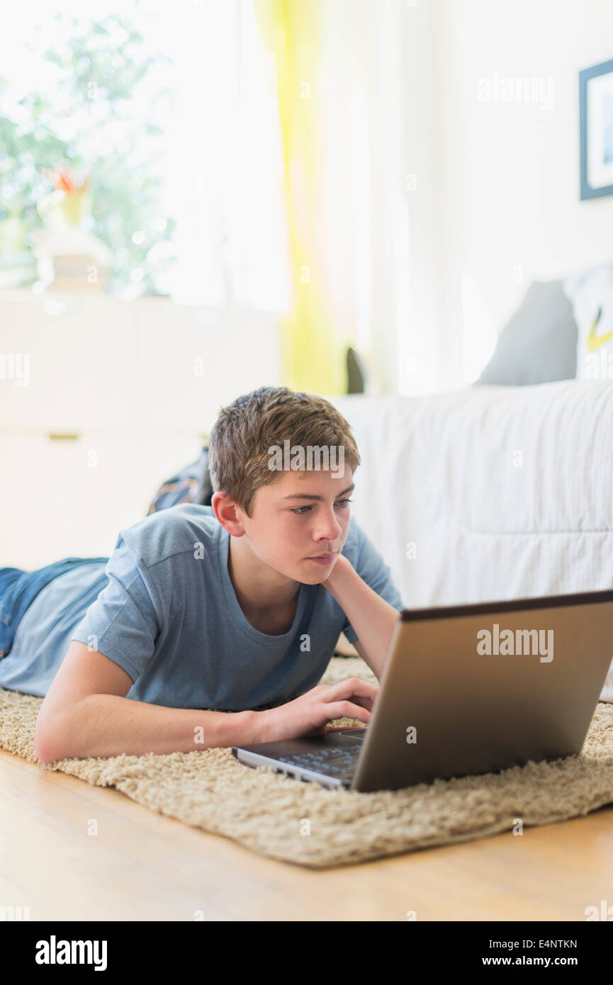 Teenage boy (16-17) using laptop Stock Photo - Alamy