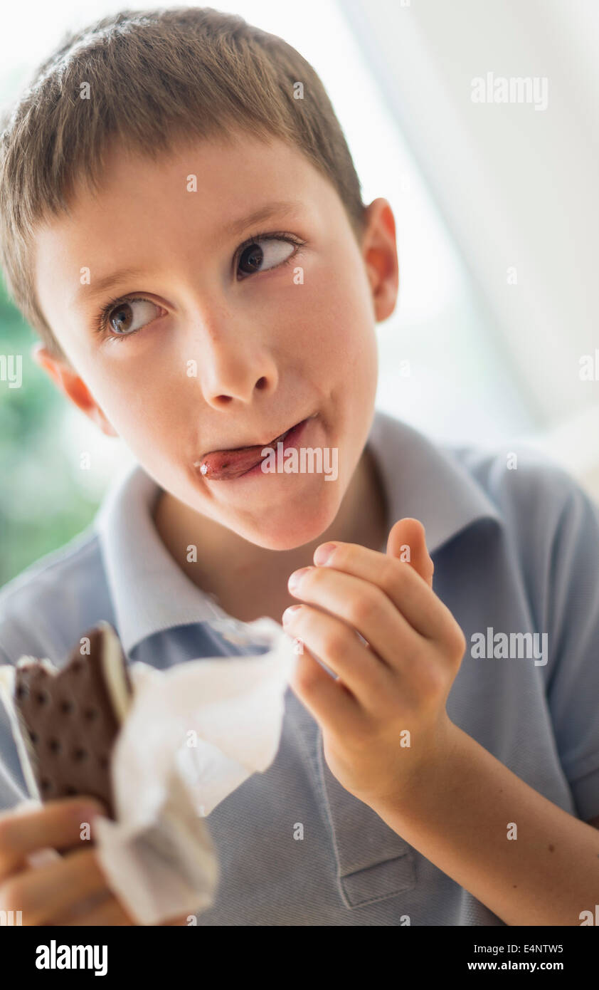 Boy (8-9) eating ice cream sandwich Stock Photo - Alamy
