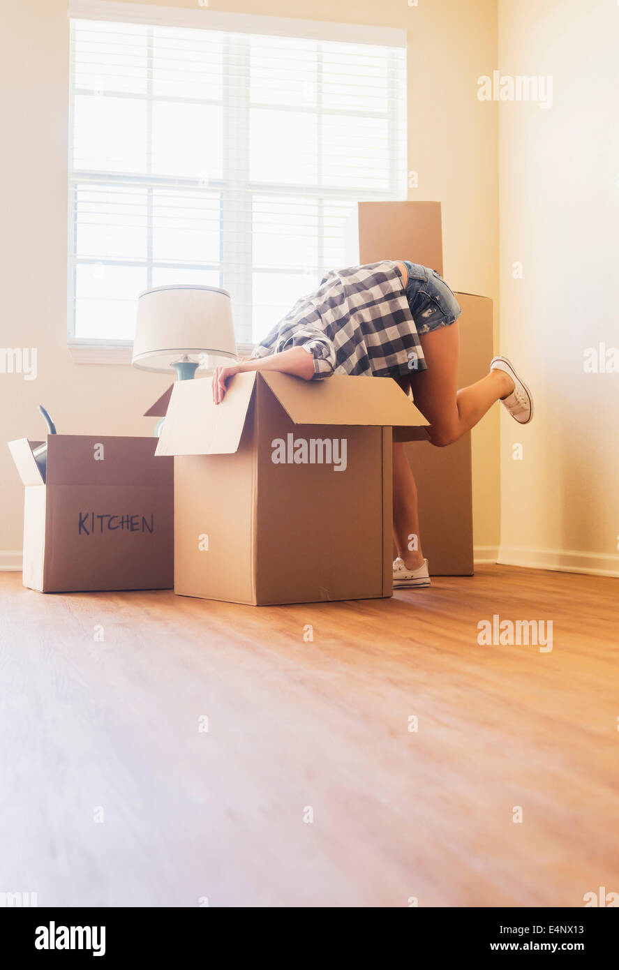 Young woman looking into box in her new house Stock Photo - Alamy