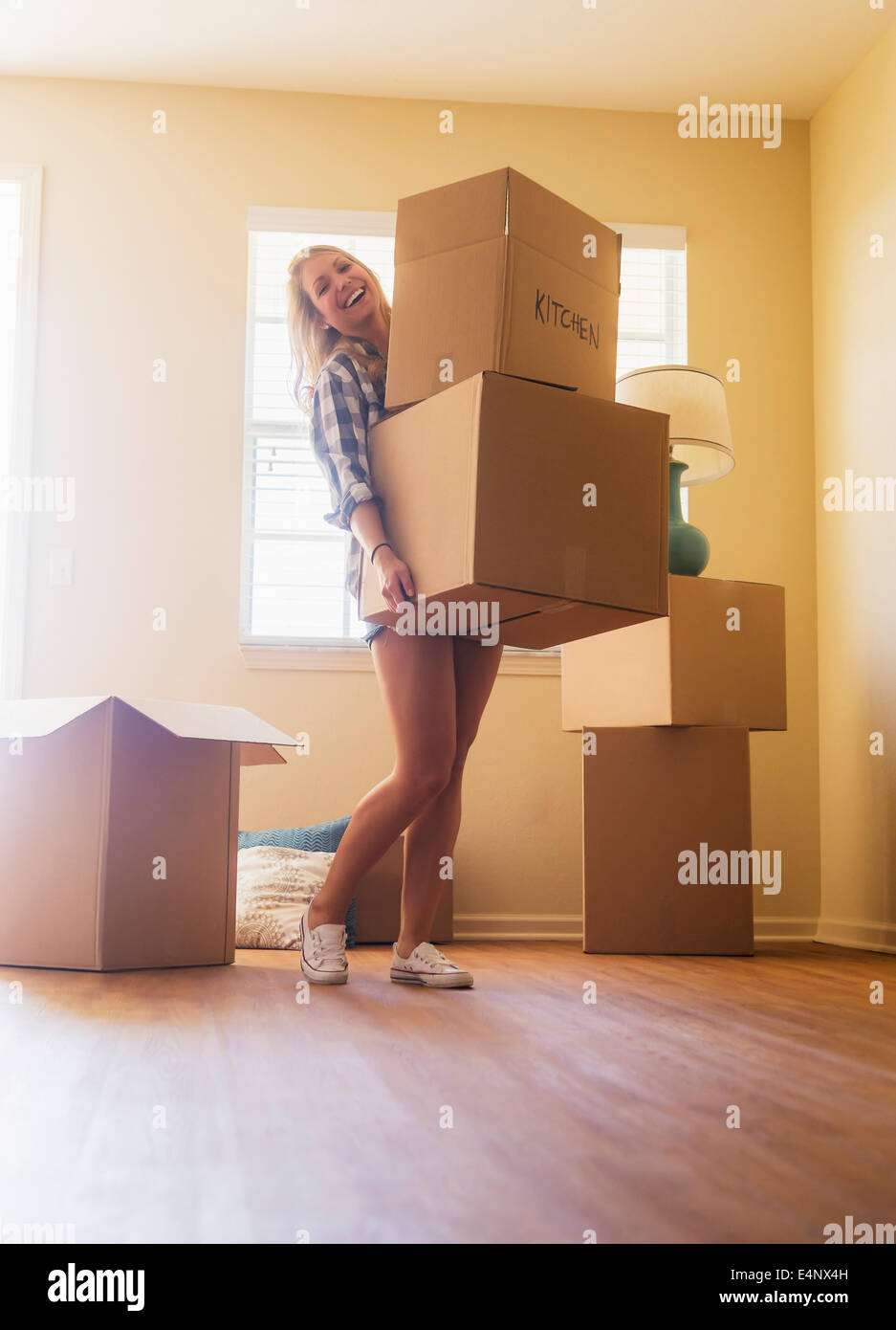 Young woman carrying boxes in her new house Stock Photo - Alamy
