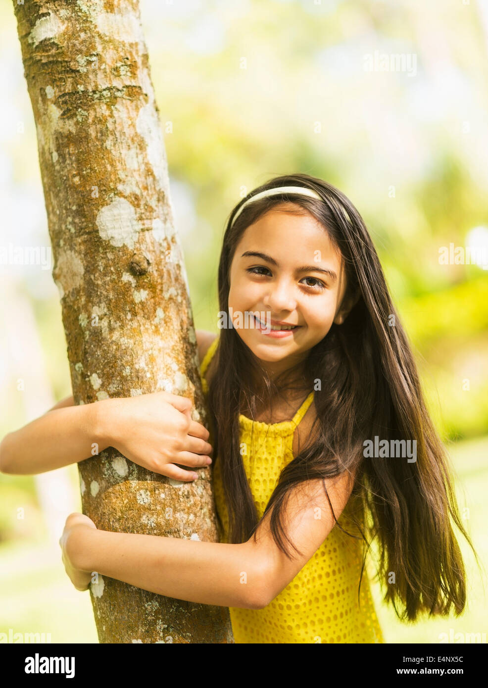 Portrait of girl (8-9) hugging tree trunk Stock Photo - Alamy