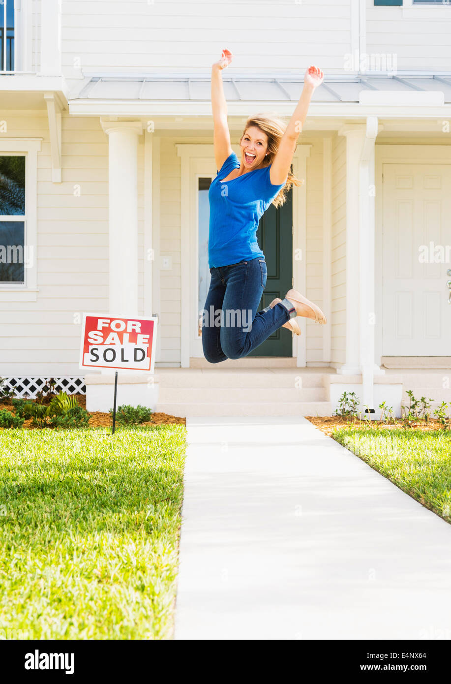 USA, Florida, Jupiter, Woman jumping in front of new house Stock Photo ...