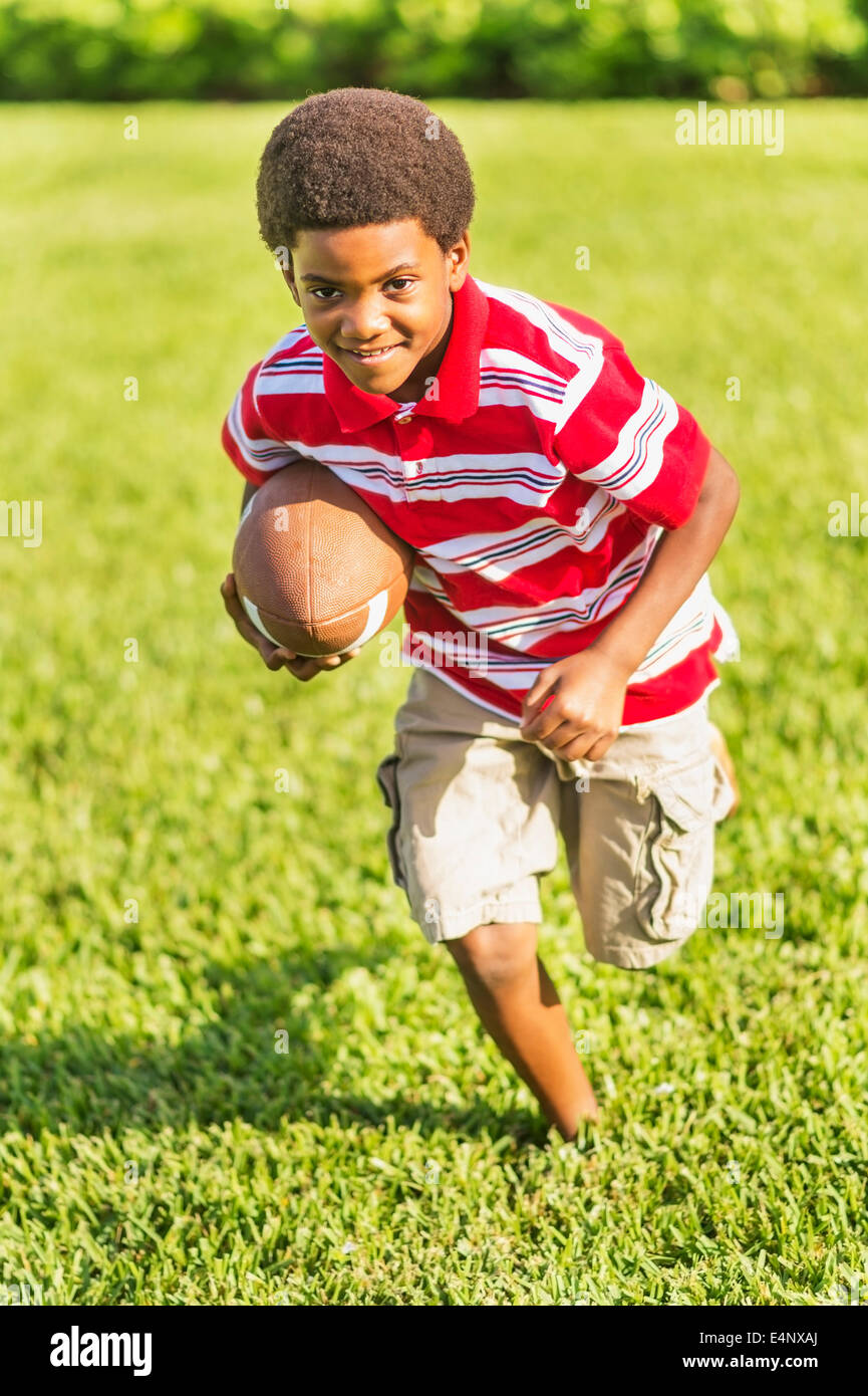 Boy (6-7) playing football Stock Photo - Alamy