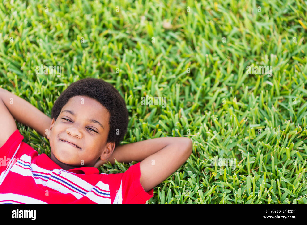 Boy (6-7) lying on grass Stock Photo - Alamy