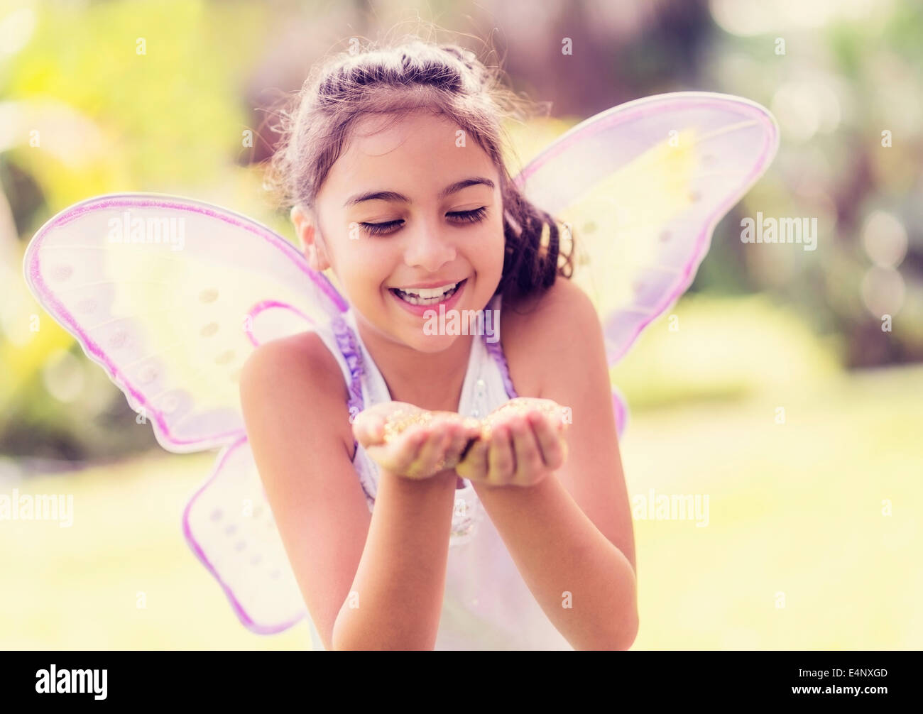 Girl (8-9) holding fairy dust in hands Stock Photo - Alamy
