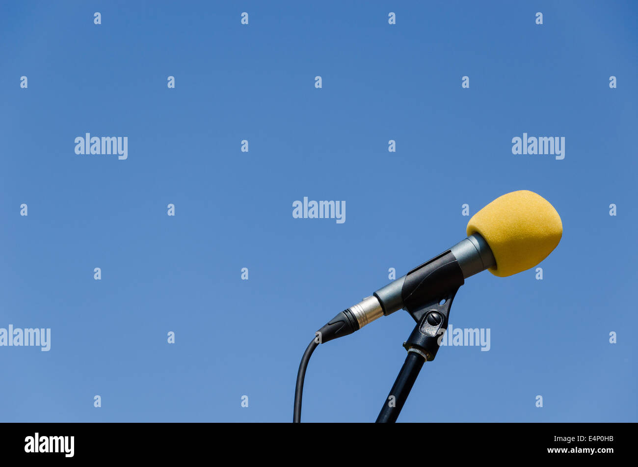 yellow microphone on blue sky background Stock Photo - Alamy