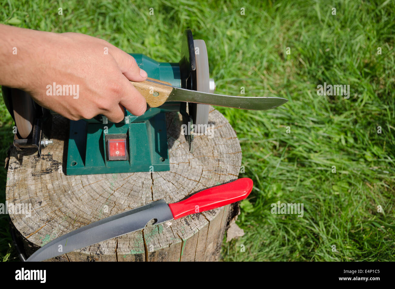 Hand grinder knives with electric tool on outdoor log Stock Photo - Alamy