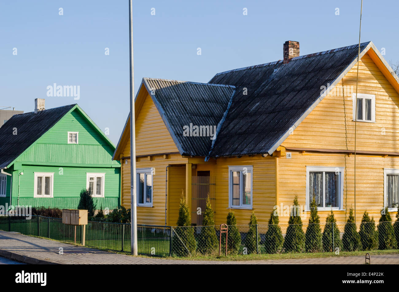 beautiful rural green and yellow painted wooden houses along the street ...