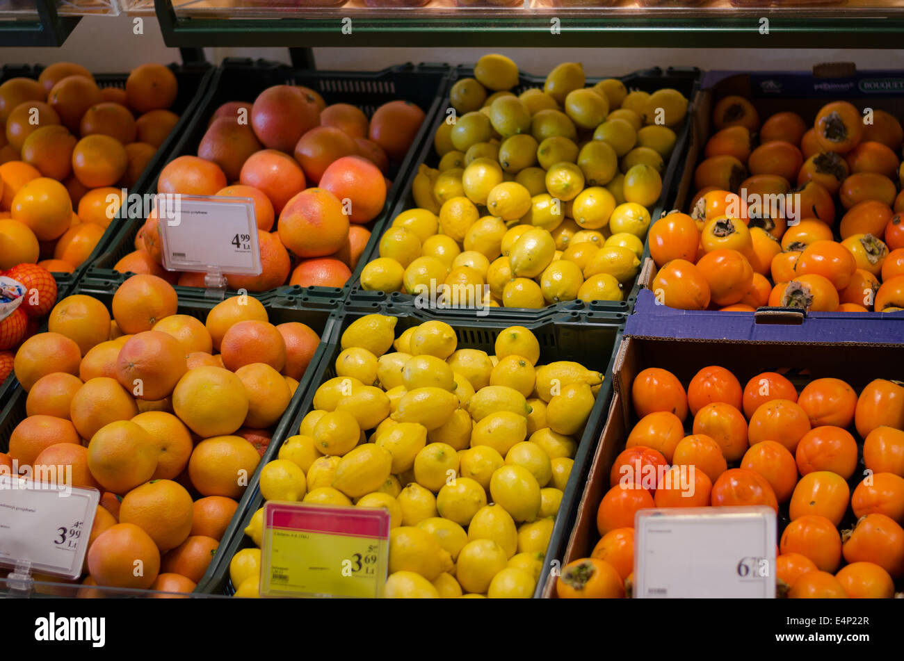 organic fresh orange lemon persimmon fruit pile in plastic boxes in ...