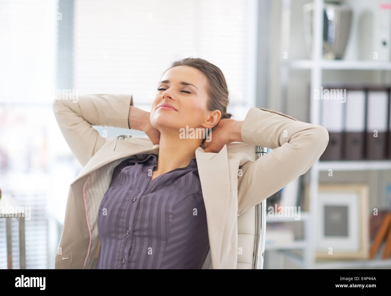 Relaxed business woman in office Stock Photo - Alamy