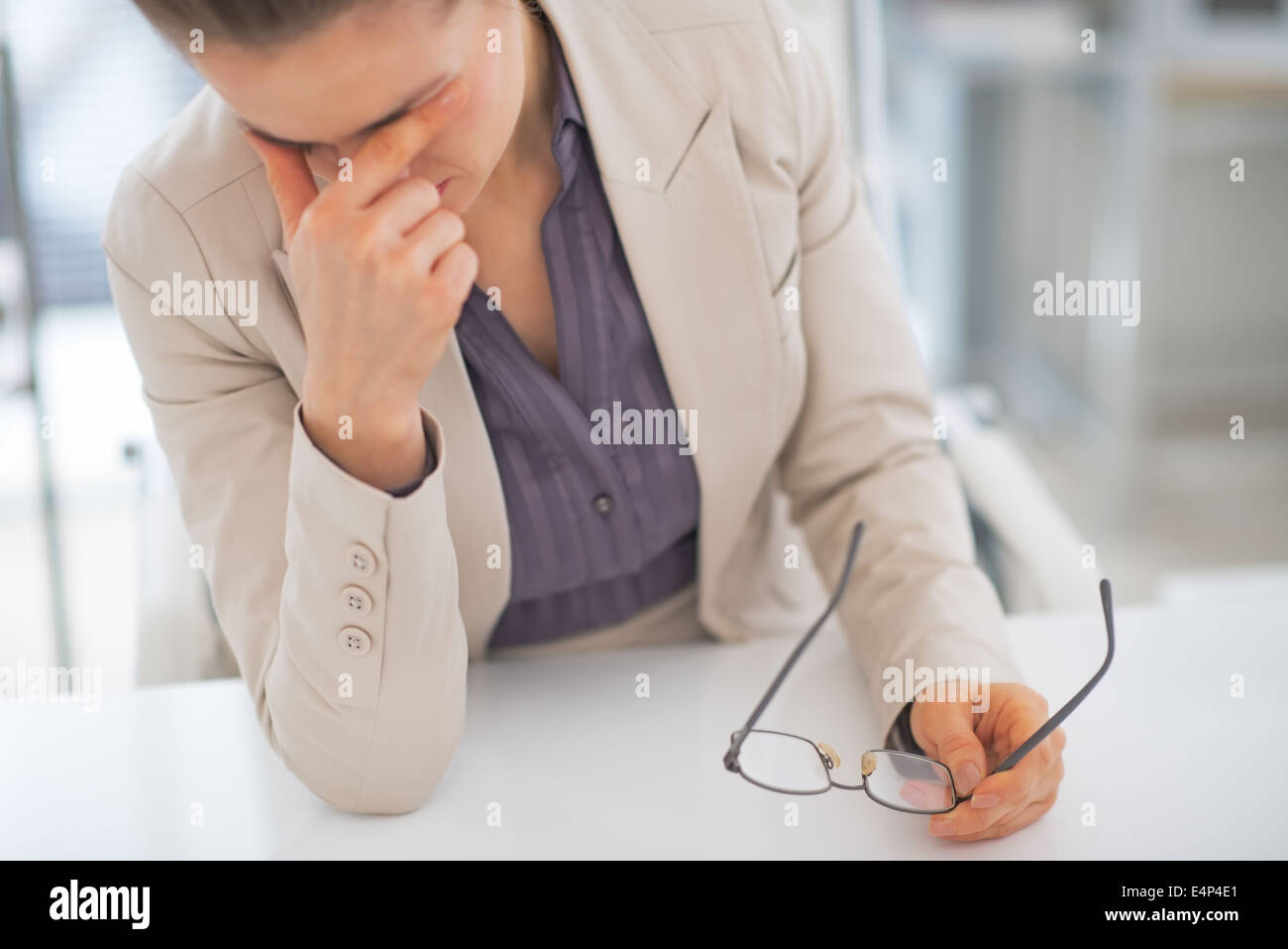Stressed business woman with eyeglasses in office Stock Photo - Alamy