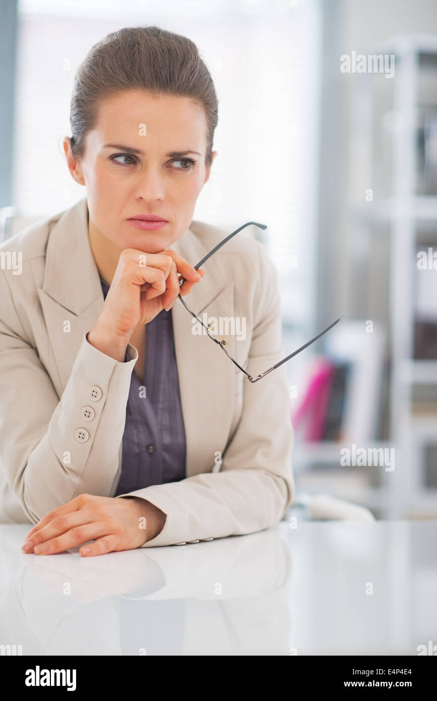 Thoughtful business woman with eyeglasses in office Stock Photo - Alamy