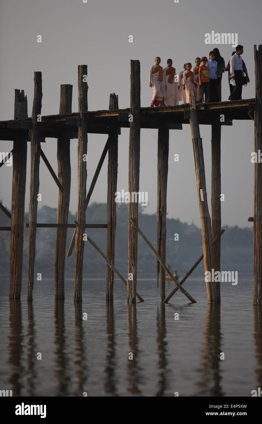 Young nuns and other people crossing U Bein Bridge, Burma. This old ...
