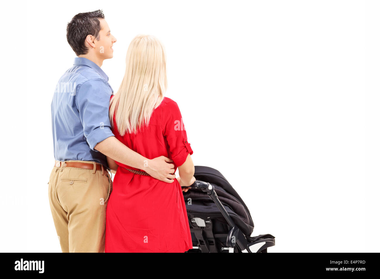Young parents pushing a baby stroller isolated against white background ...