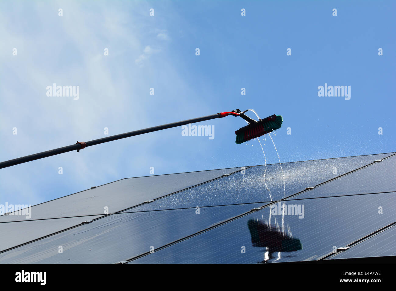 Solar panels on a residential property are cleaned using a high reach ...