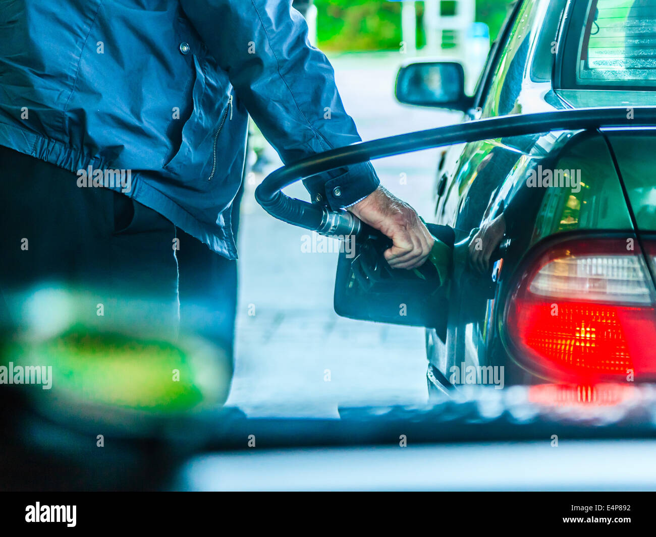 Male hand refilling the car with gas or petrol on filling station ...