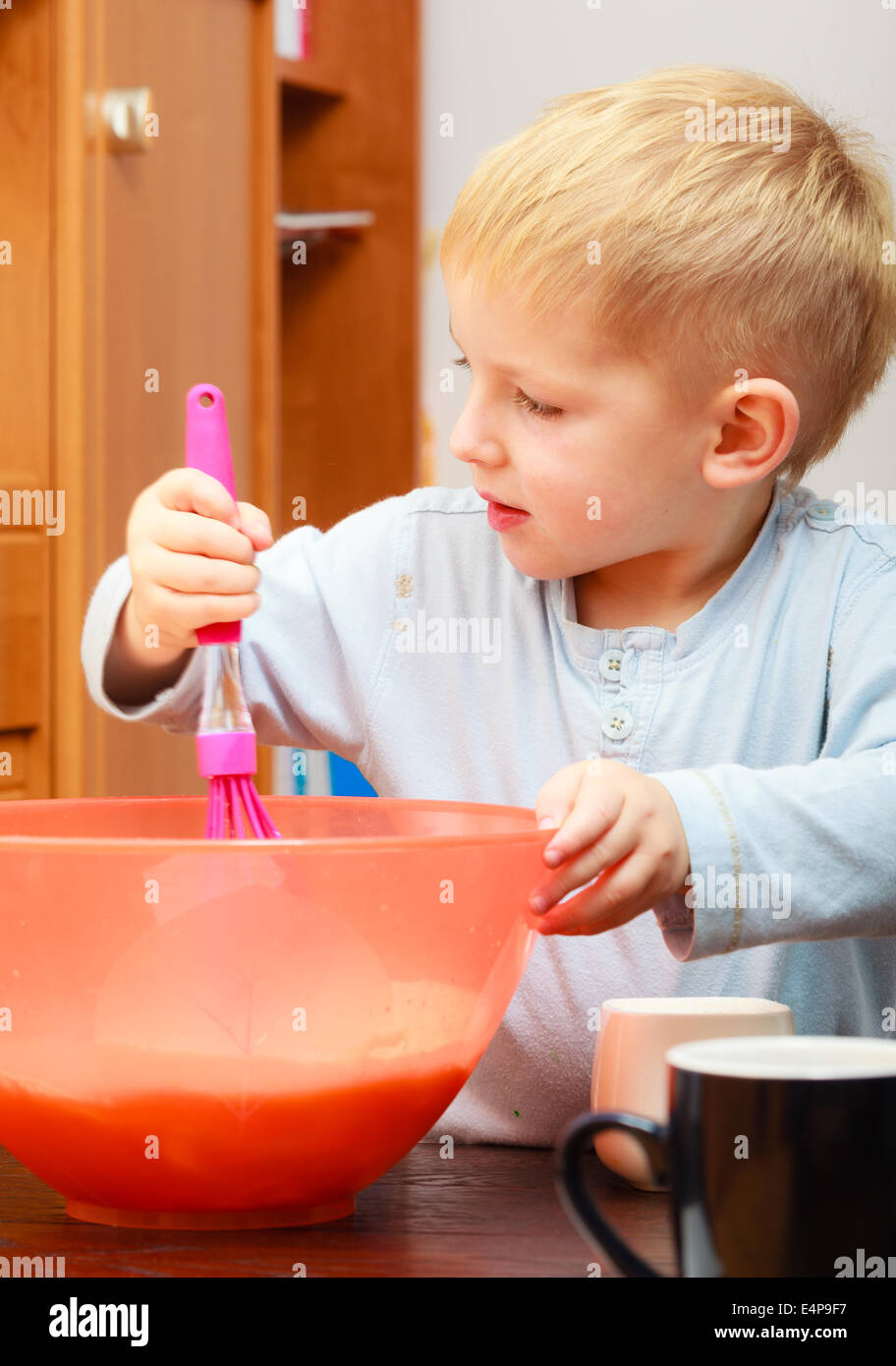Happy childhood. Boy kid baking cake. Child preschooler beating dough ...