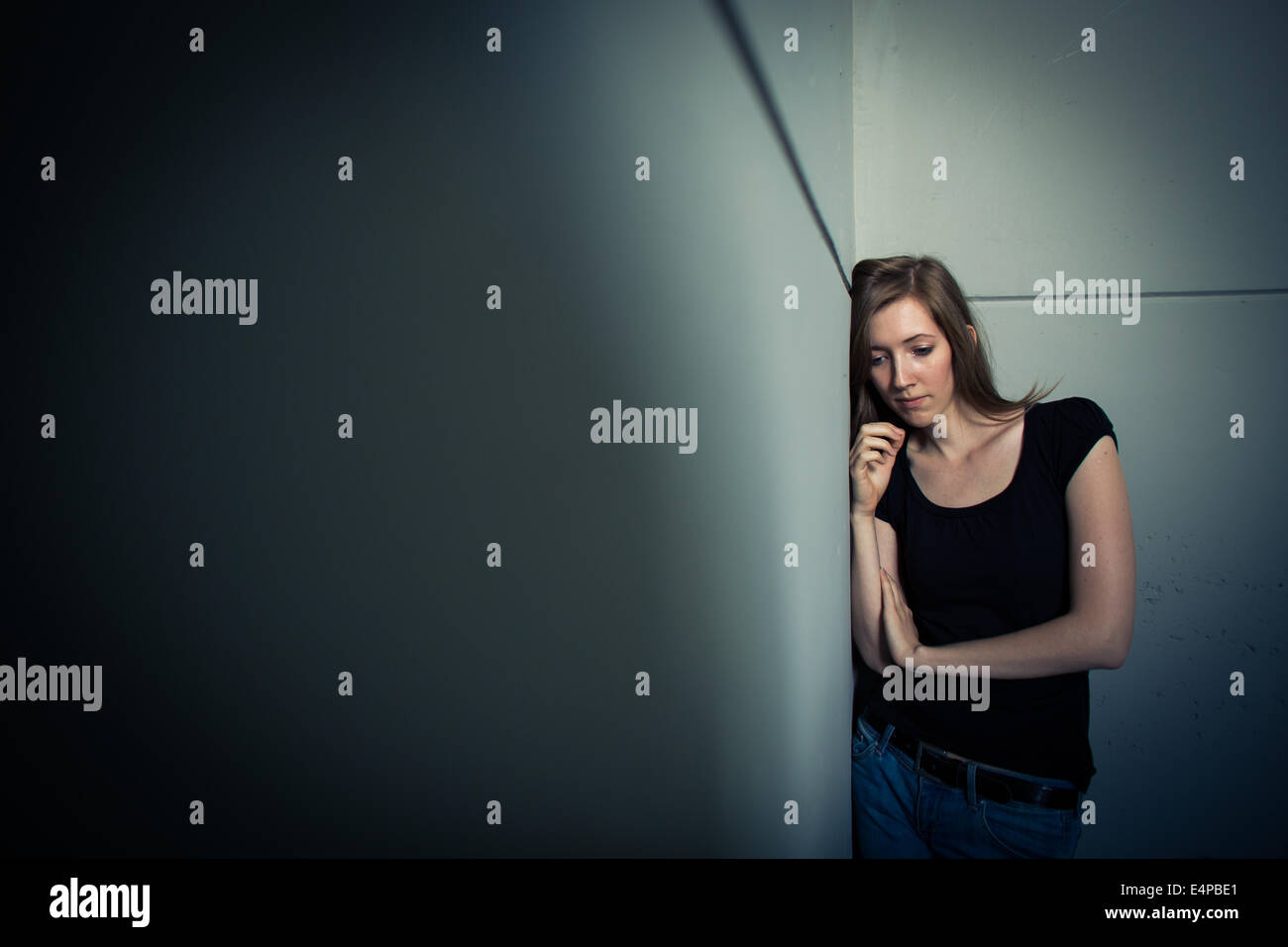 Young woman suffering from a severe depression (very harsh lighting is ...