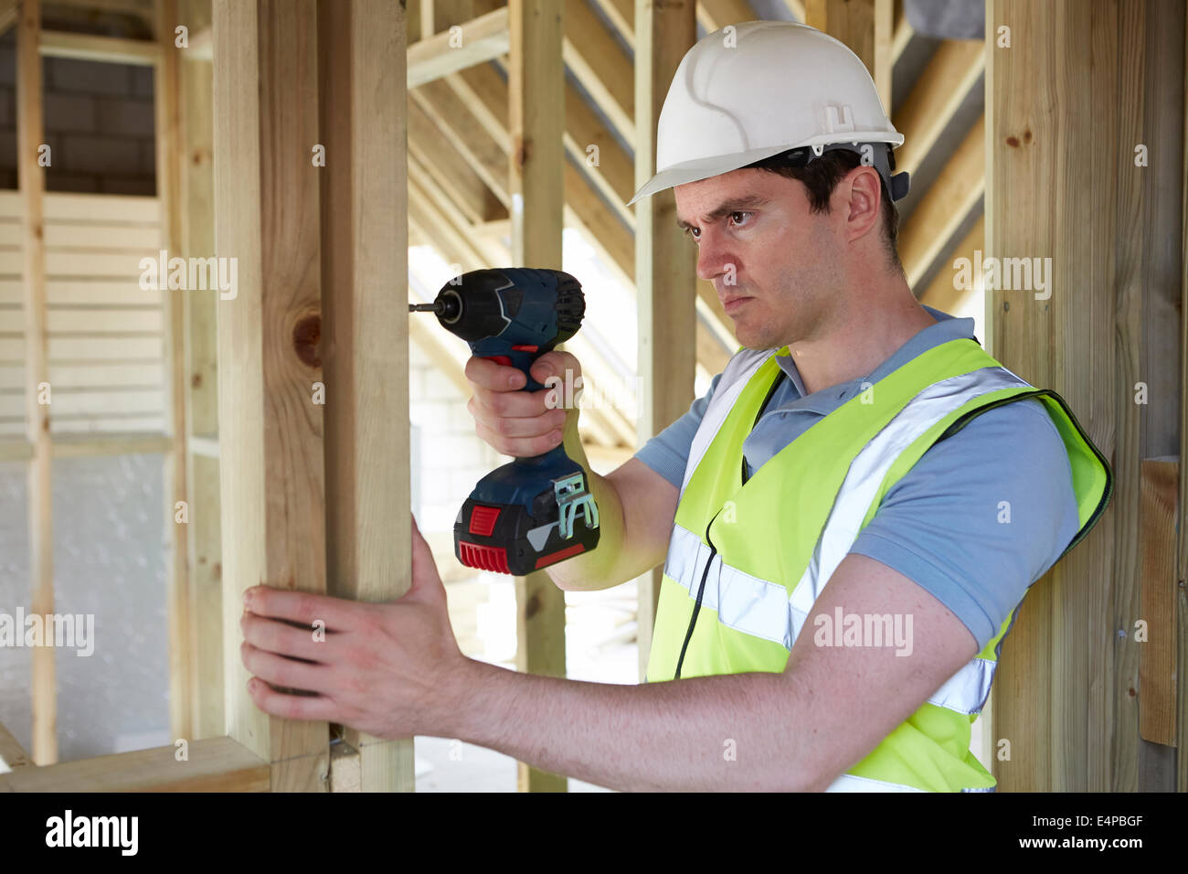 Construction Worker Using Cordless Drill On House Build Stock Photo - Alamy