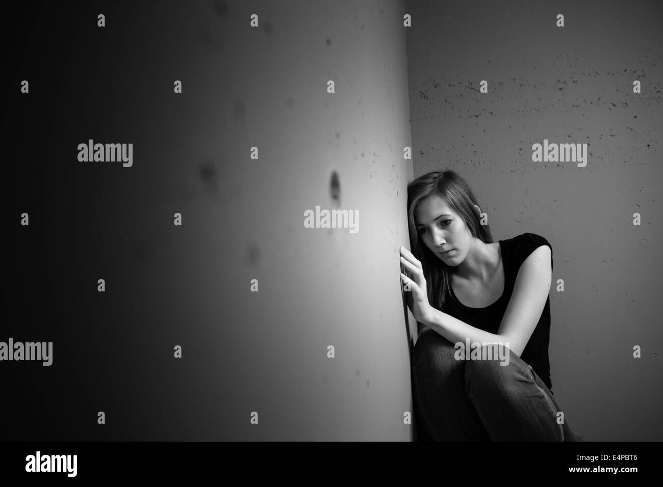 Young woman suffering from a severe depression (very harsh lighting is ...