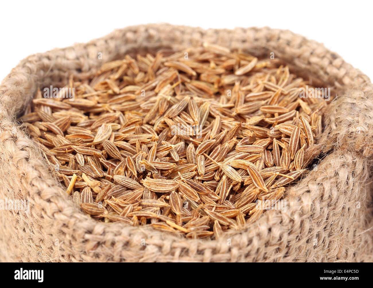 Cumin on sack bag over white background Stock Photo - Alamy