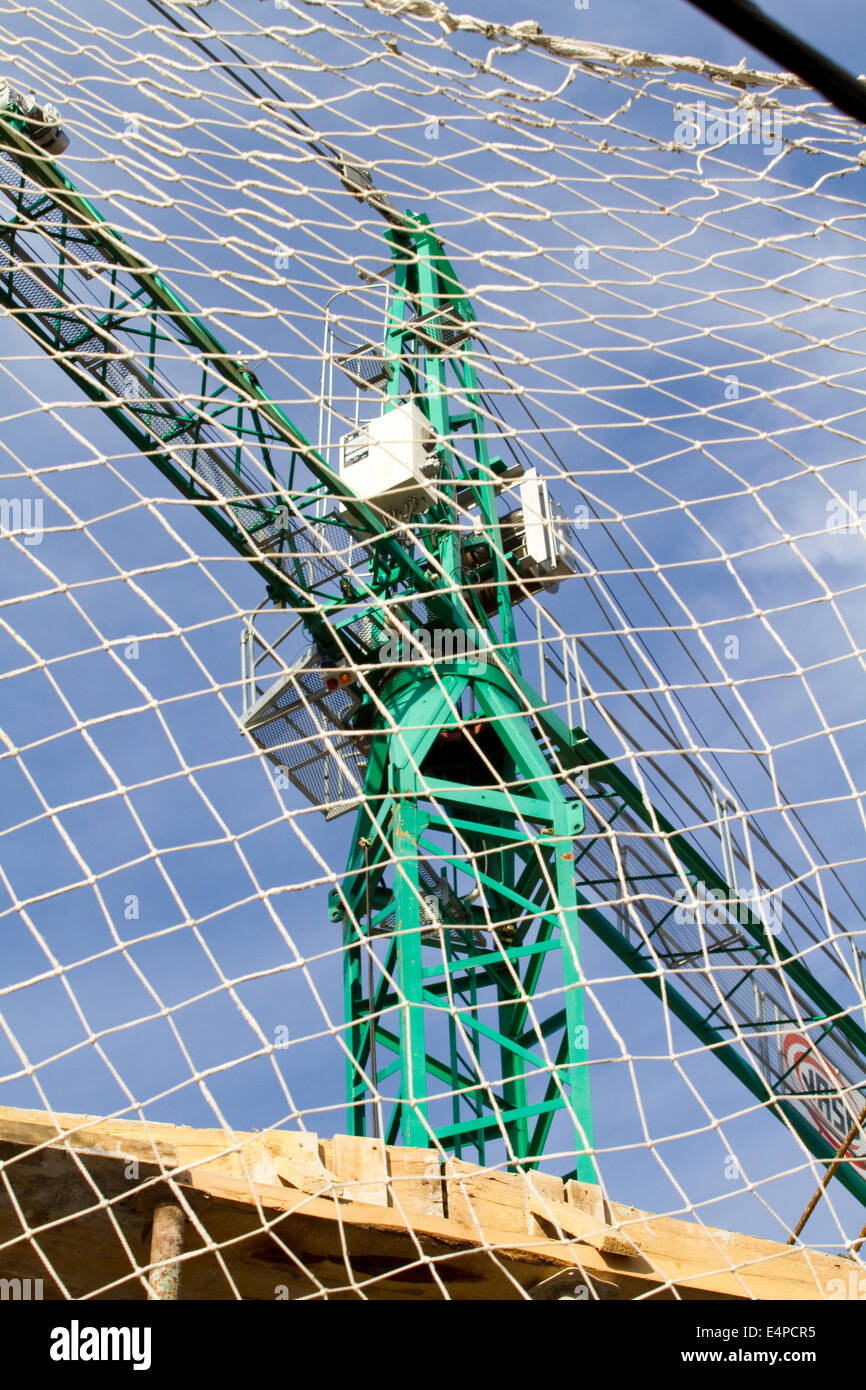Industrial Crane behind safety net, under construction building ...