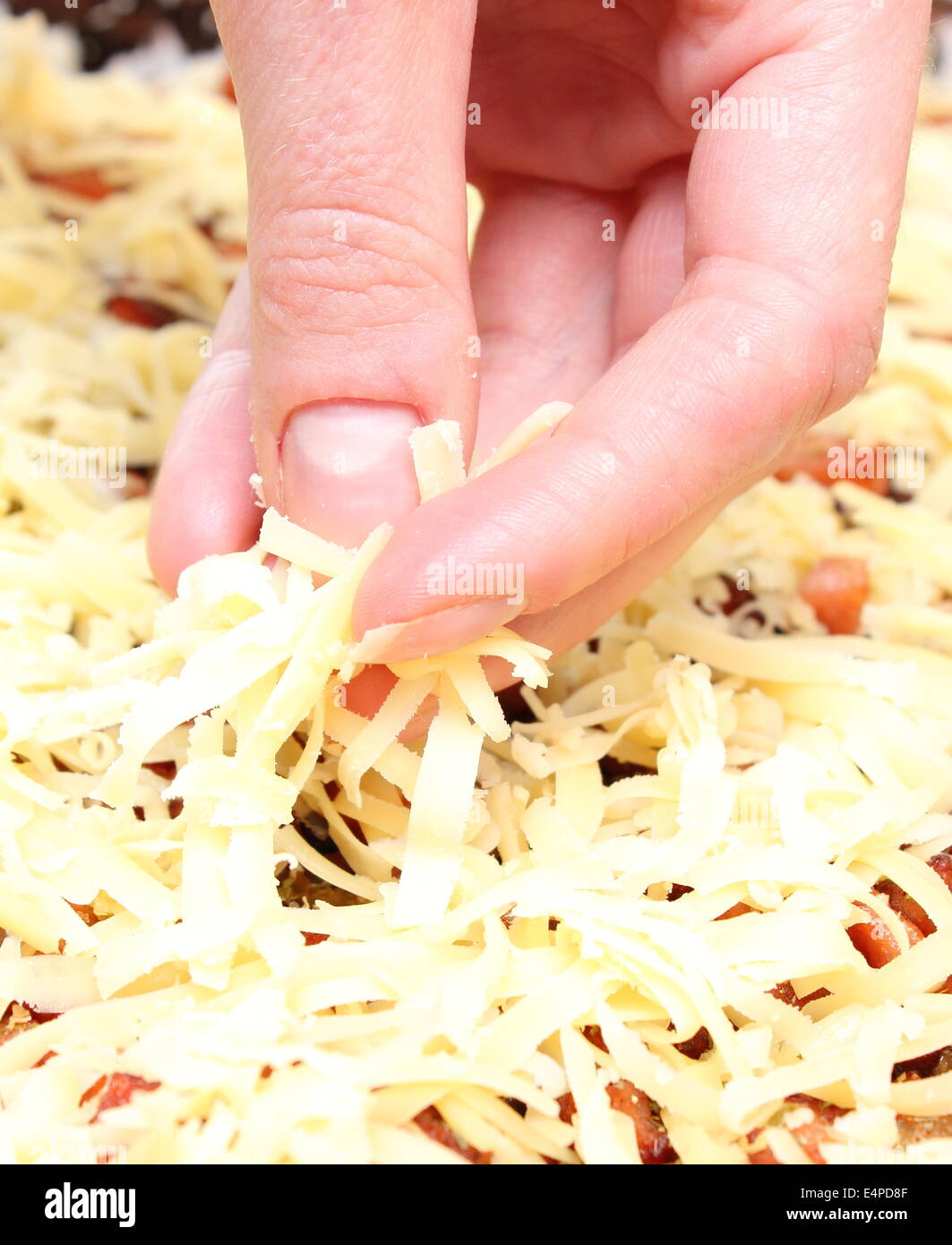 Cook's hand putting cheese on the pizza Stock Photo - Alamy