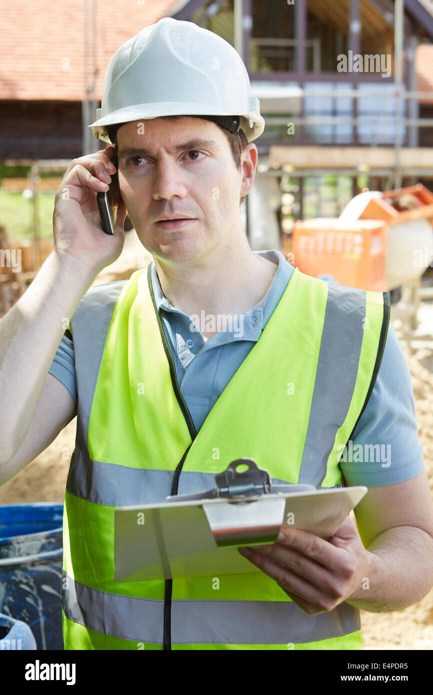 Construction Worker On Building Site Using Mobile Phone Stock Photo - Alamy