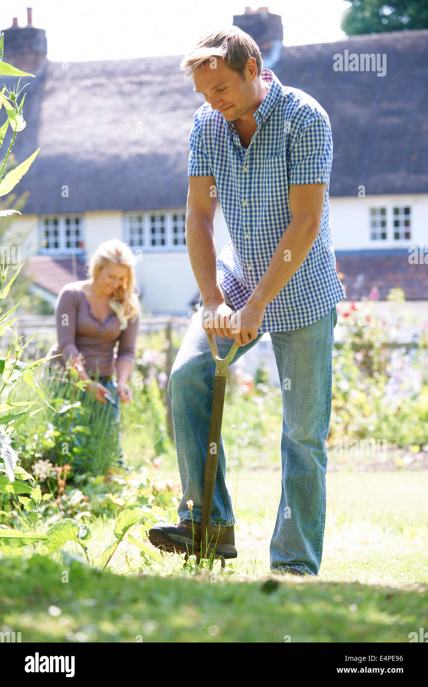 Couple Working In Garden At Home Together Stock Photo - Alamy