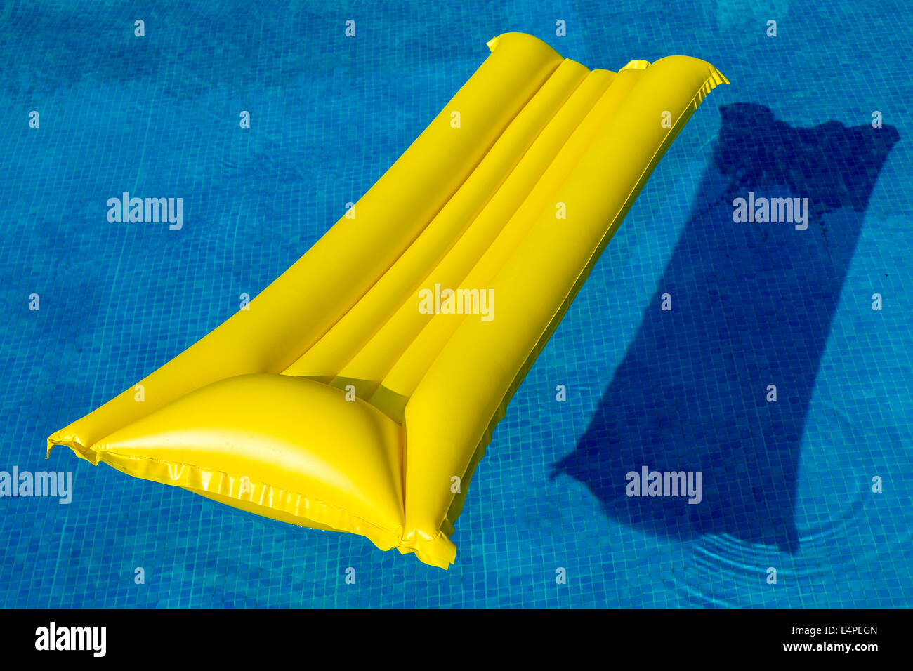 Yellow lilo, in a swimming pool Stock Photo - Alamy