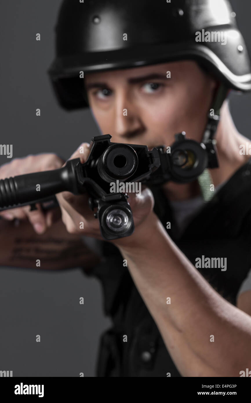Gunfire, paintball sport player wearing protective helmet aiming pistol ...