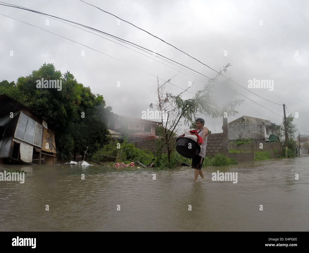 Cavite Province, Philippines. 16th July, 2014. A man wades on flood ...