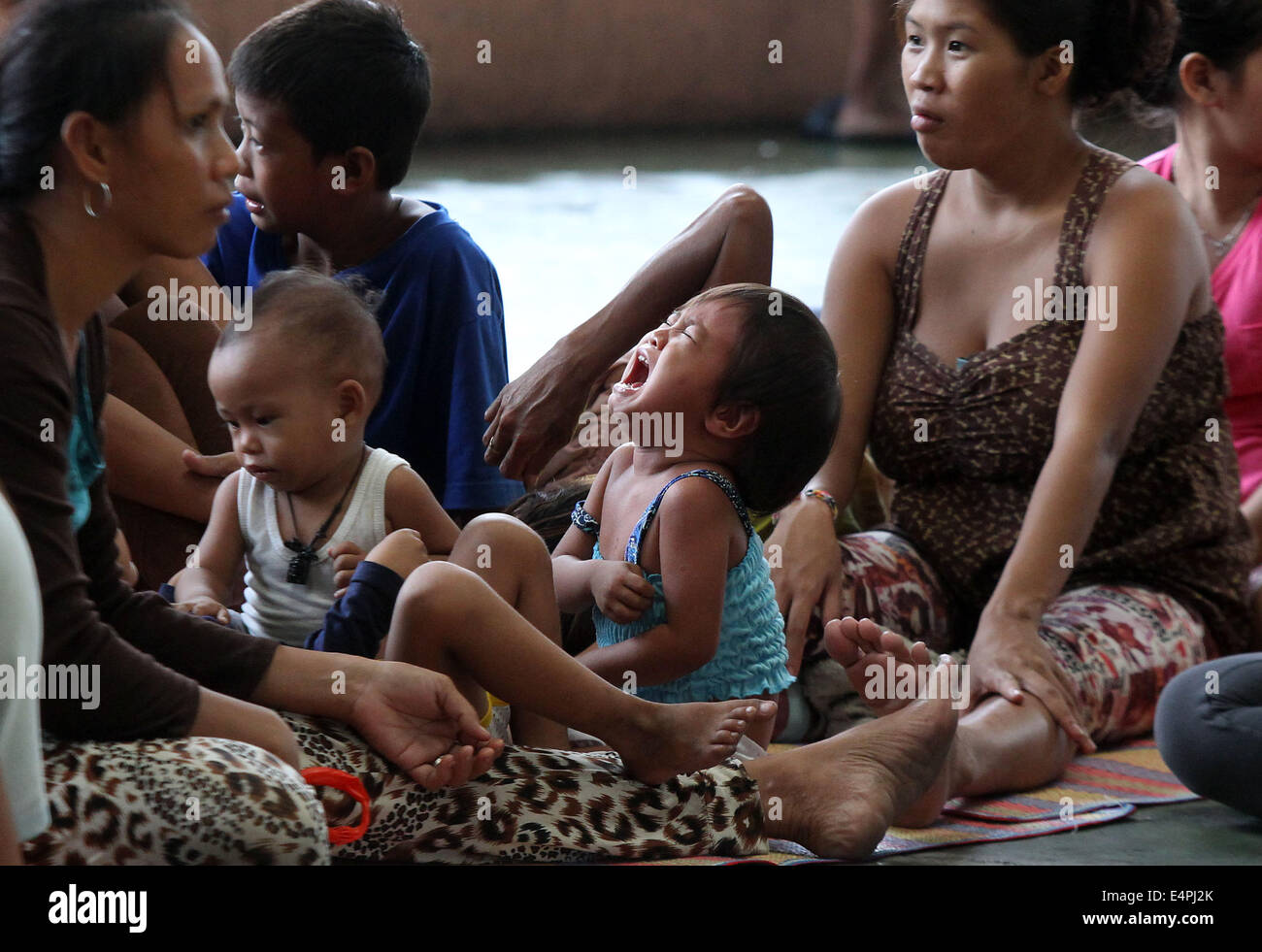 Manila, Philippines. 16th July, 2014. A girl cries as other residents ...