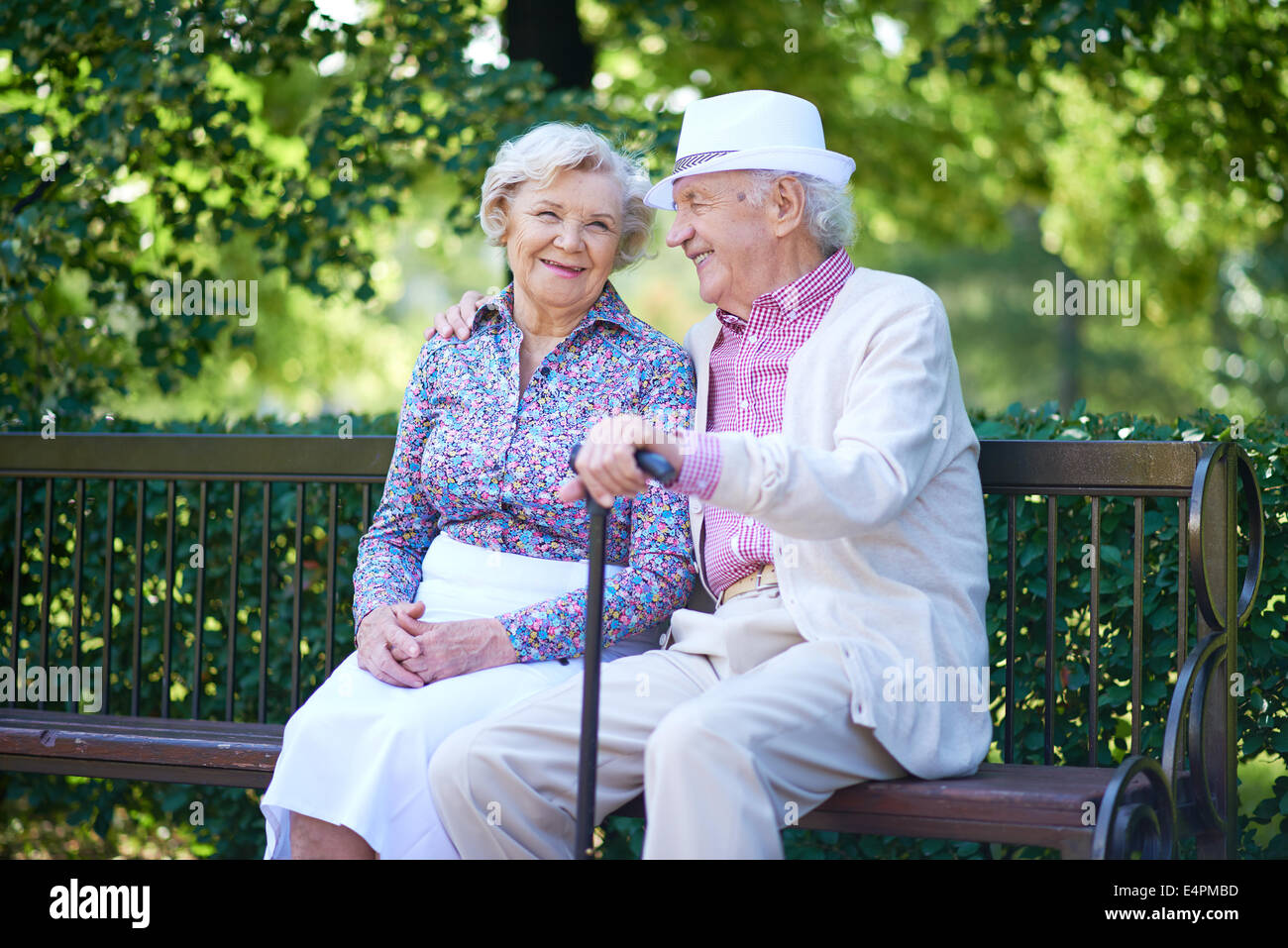 Happy seniors talking while sitting in the park Stock Photo - Alamy