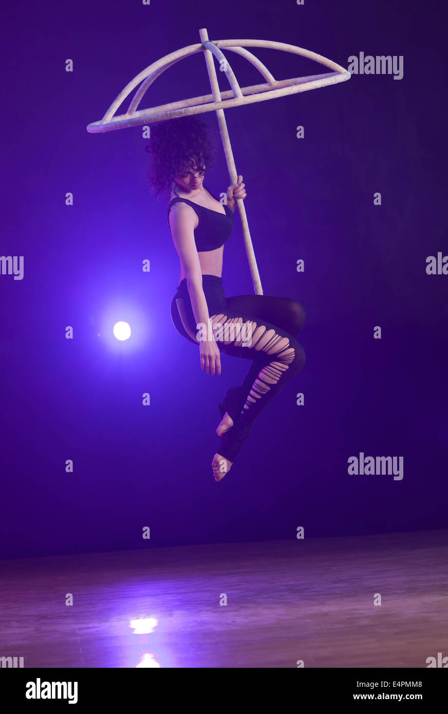 Young and fit woman performing a contemporary dance pose on a stage ...