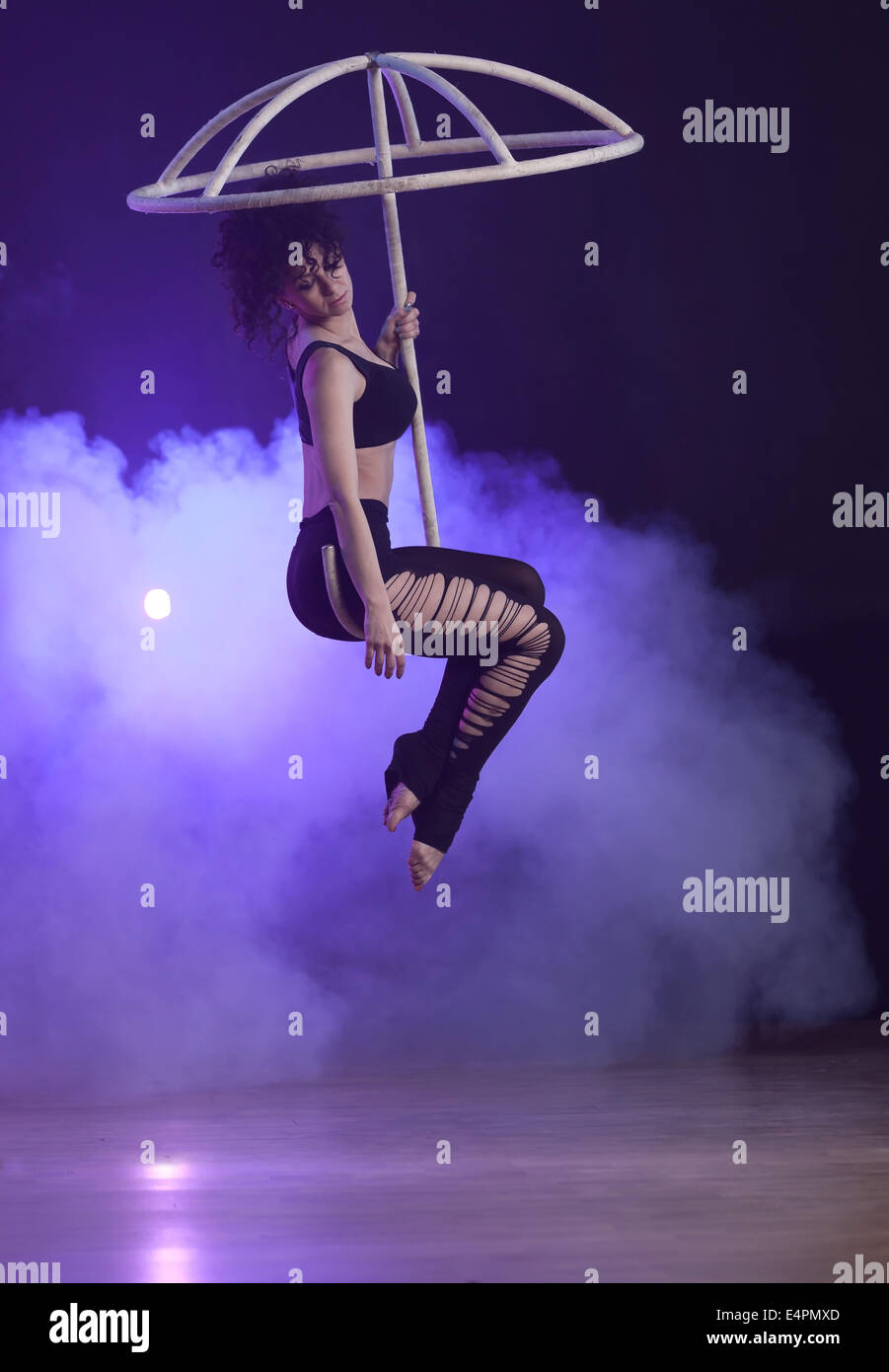 Young and fit woman performing a contemporary dance pose on a stage ...