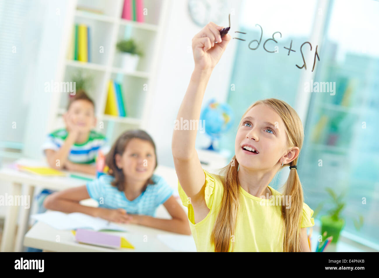 Portrait of lovely girl doing sums on transparent board with ...