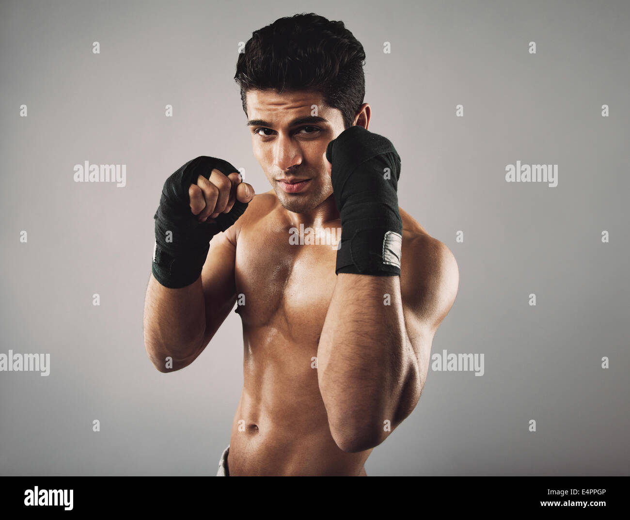 Portrait of handsome young man shadow boxing to stay fit. Studio shot ...