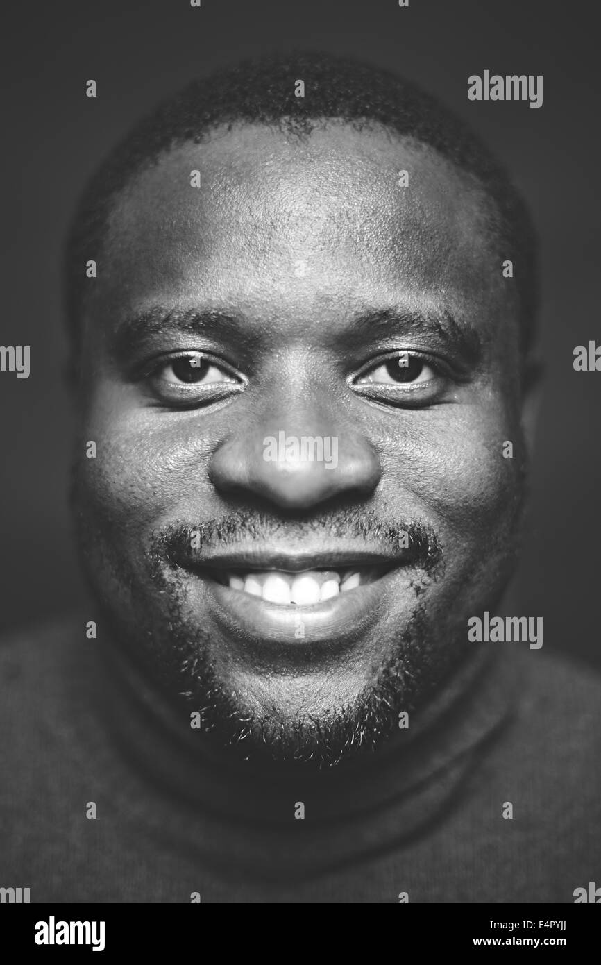 Low-key image of happy guy looking at camera with smile Stock Photo - Alamy
