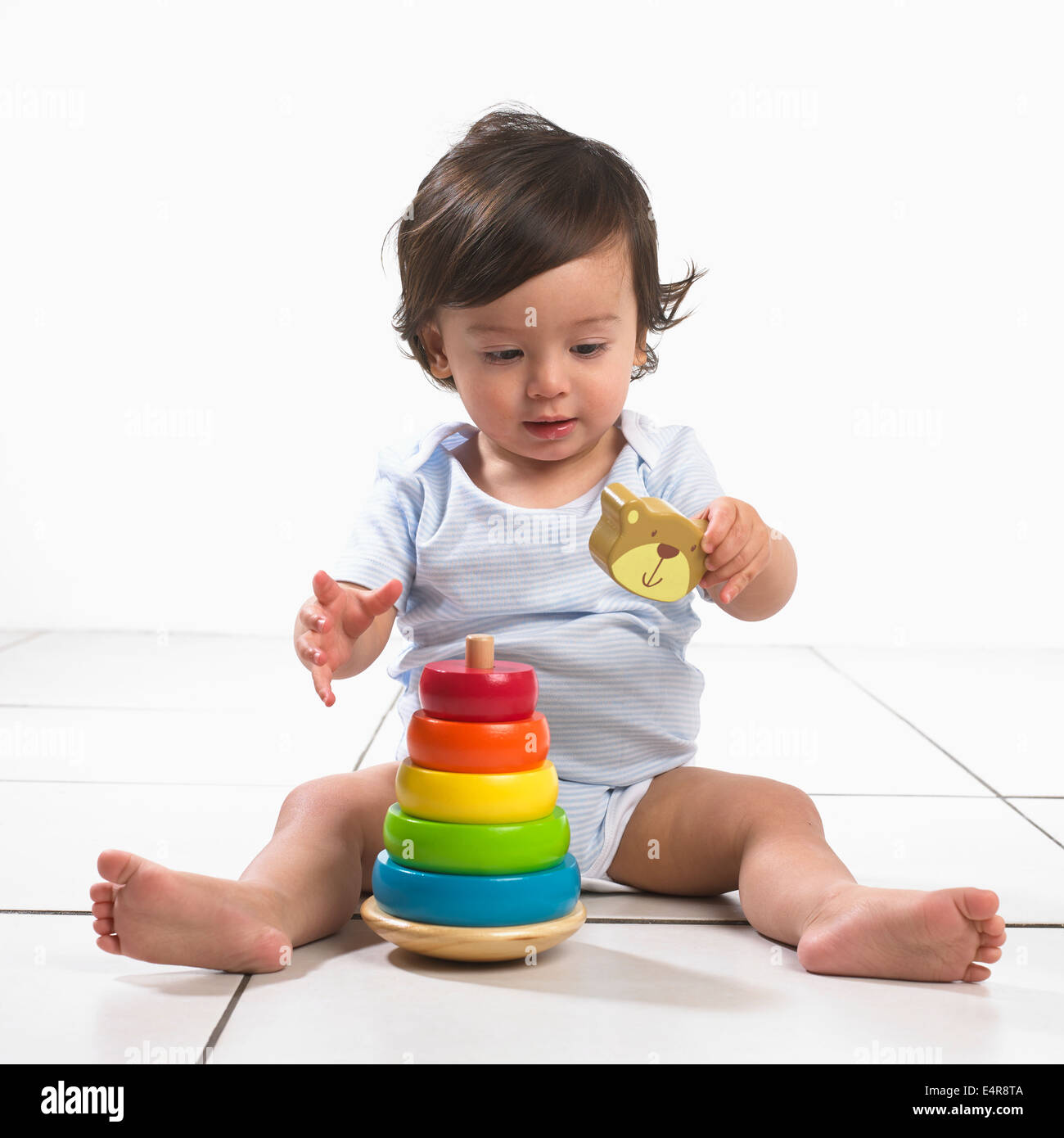 Toddler boy playing with wooden stacking hoop toy Stock Photo - Alamy